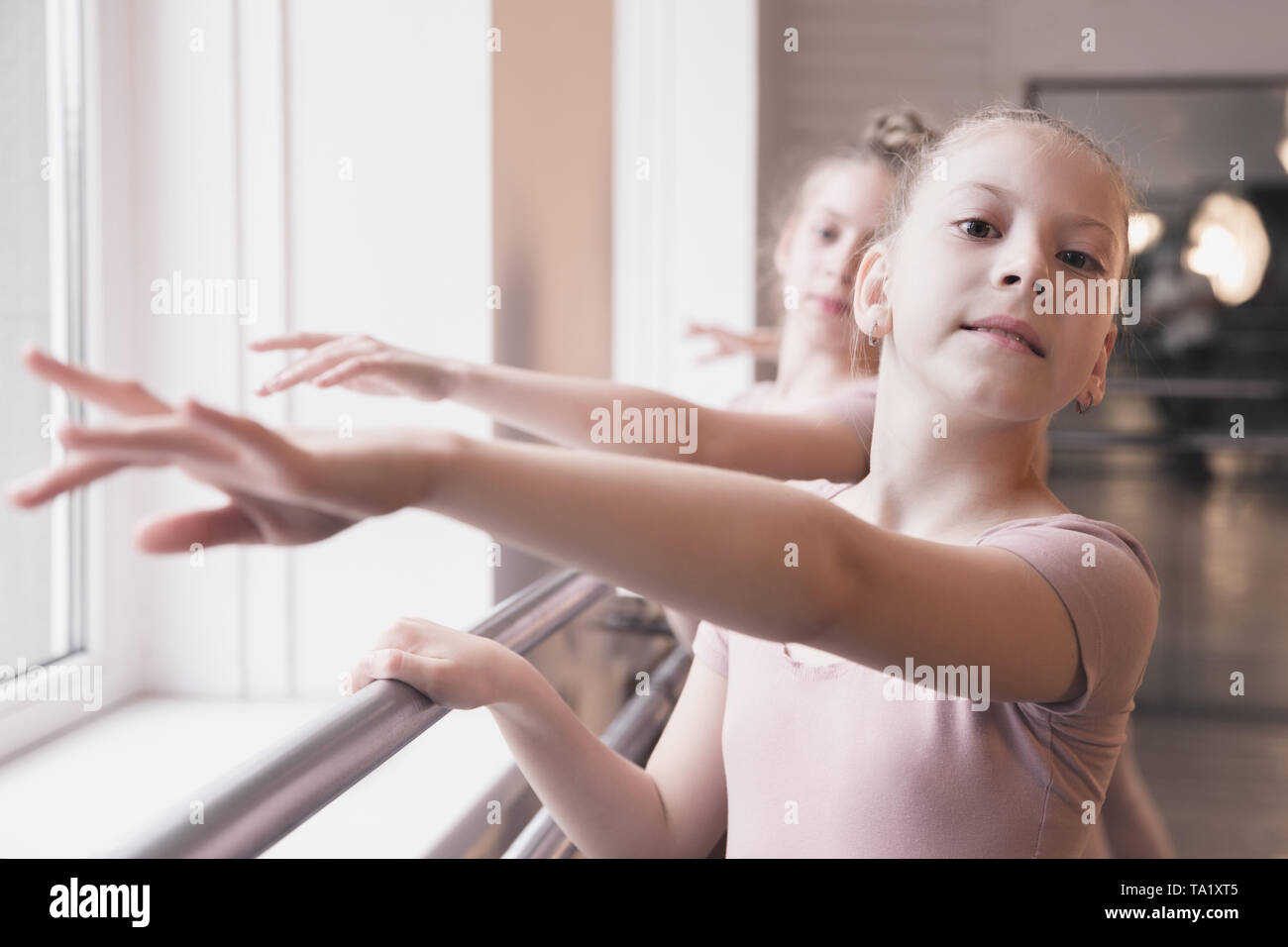 Young graceful female ballet dancers dancing at training studio. Beauty ...