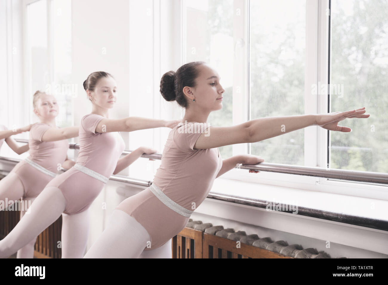 Young graceful female ballet dancers dancing at training studio. Beauty ...