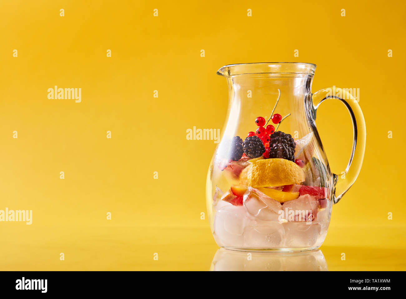 Preparation of homemade refreshing cold fruit punch in a glass jar on ...