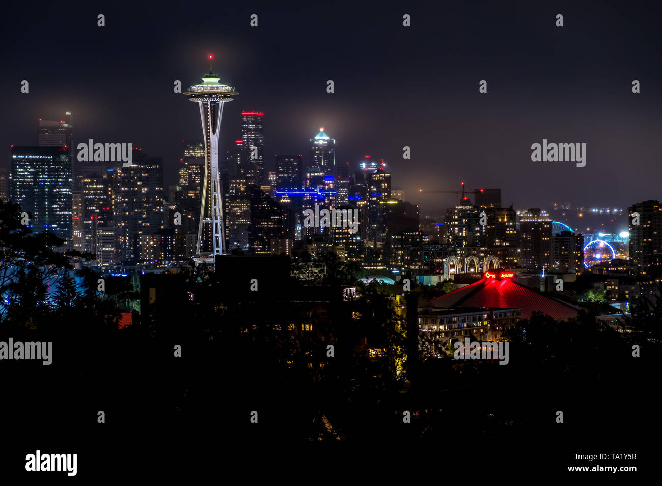 Seattle skyline on a cloudy night with the Space Needle in foreground ...