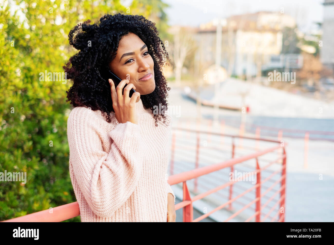 Black woman holding her phone hi-res stock photography and images - Alamy