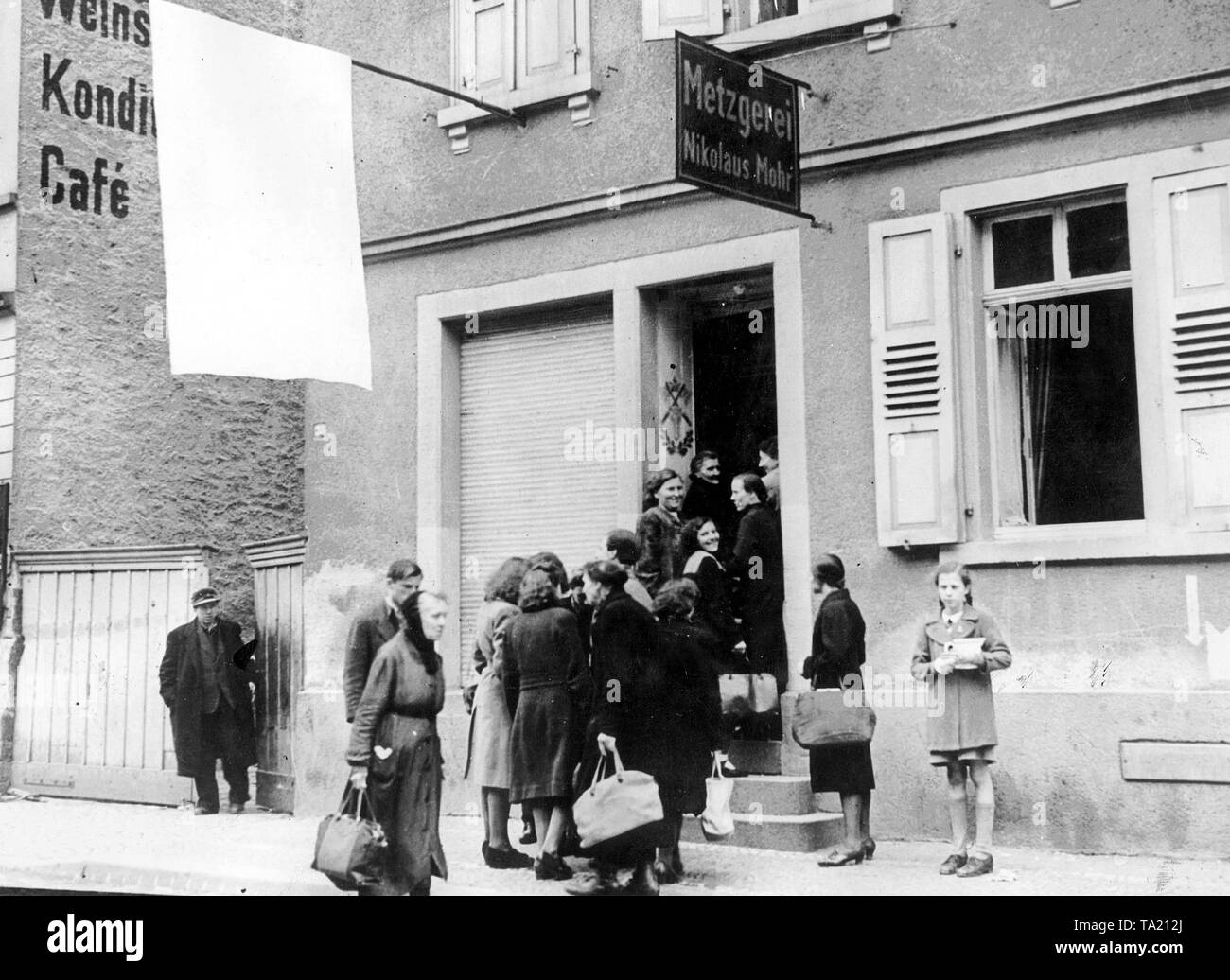 Women stand in line under a white flag to get their meat rations Stock ...