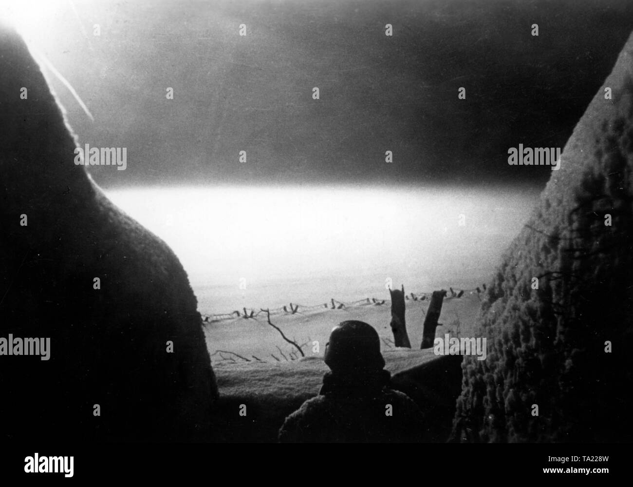 A German soldier watches the frozen Gulf of Finland at night. The ice ...