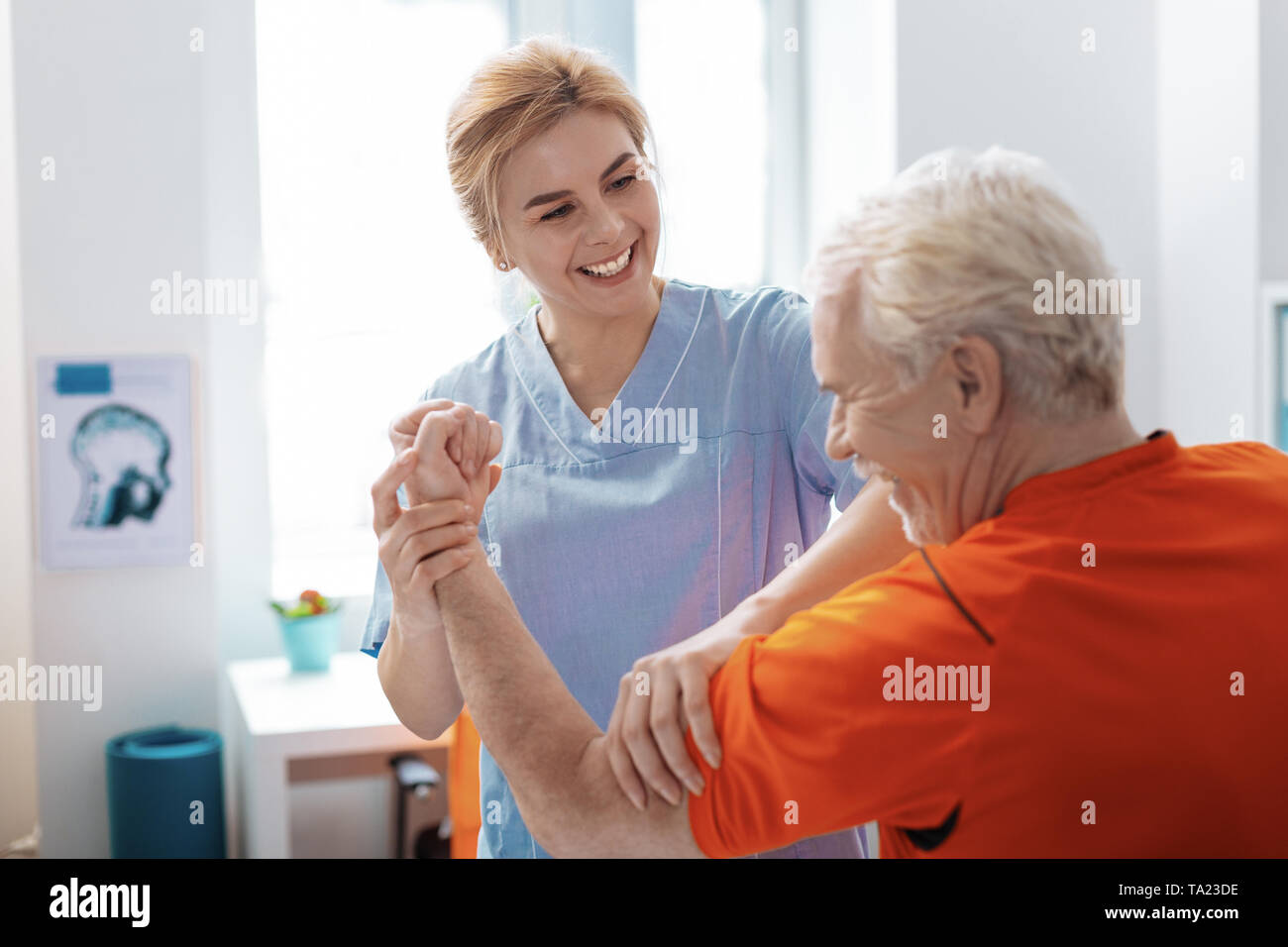 Joyful positive nurse smiling to her patient Stock Photo - Alamy