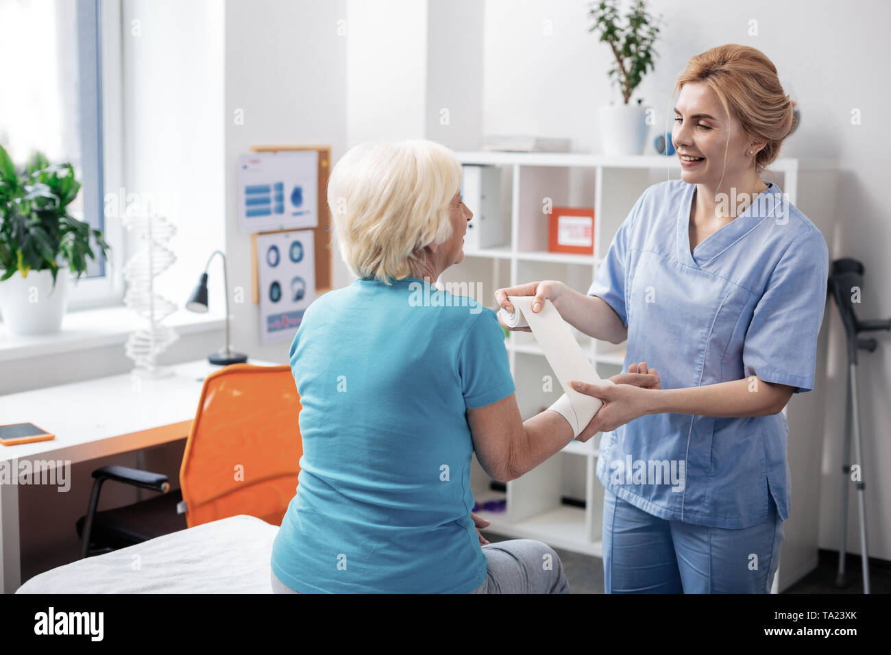 Positive friendly nurse standing near her patient Stock Photo - Alamy