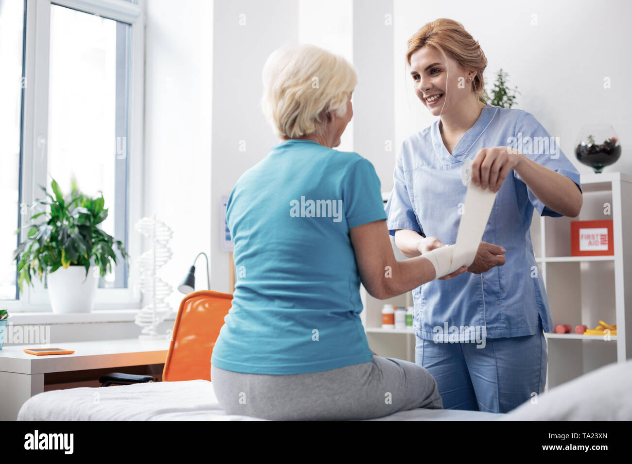 Nice friendly female nurse doing her job Stock Photo - Alamy