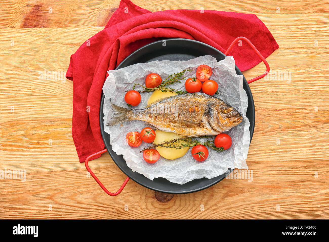 Pan with grilled dorado fish and vegetables on wooden background Stock ...