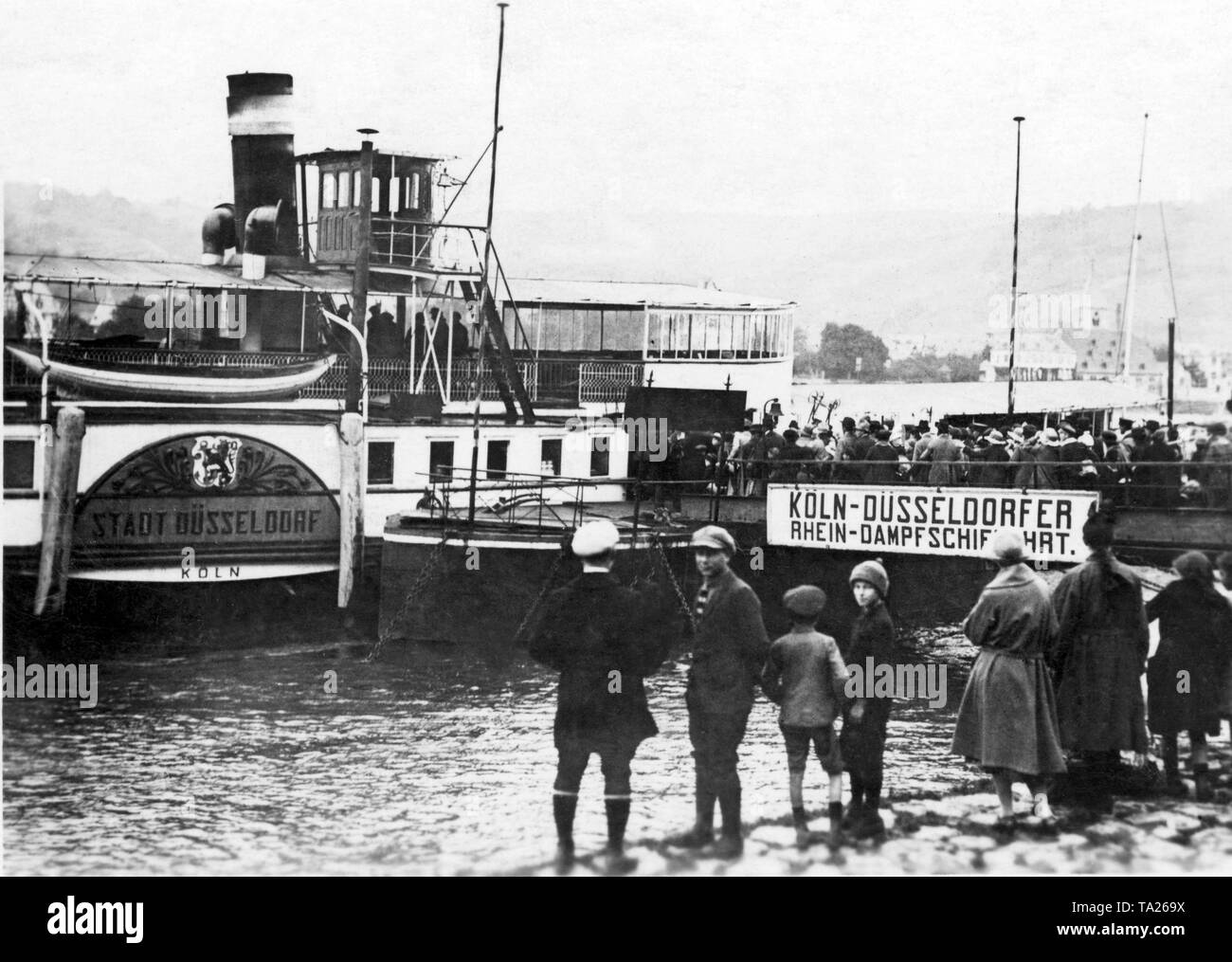 Expellees from the Ruhr area are waiting on the boat dock for a steamer ...