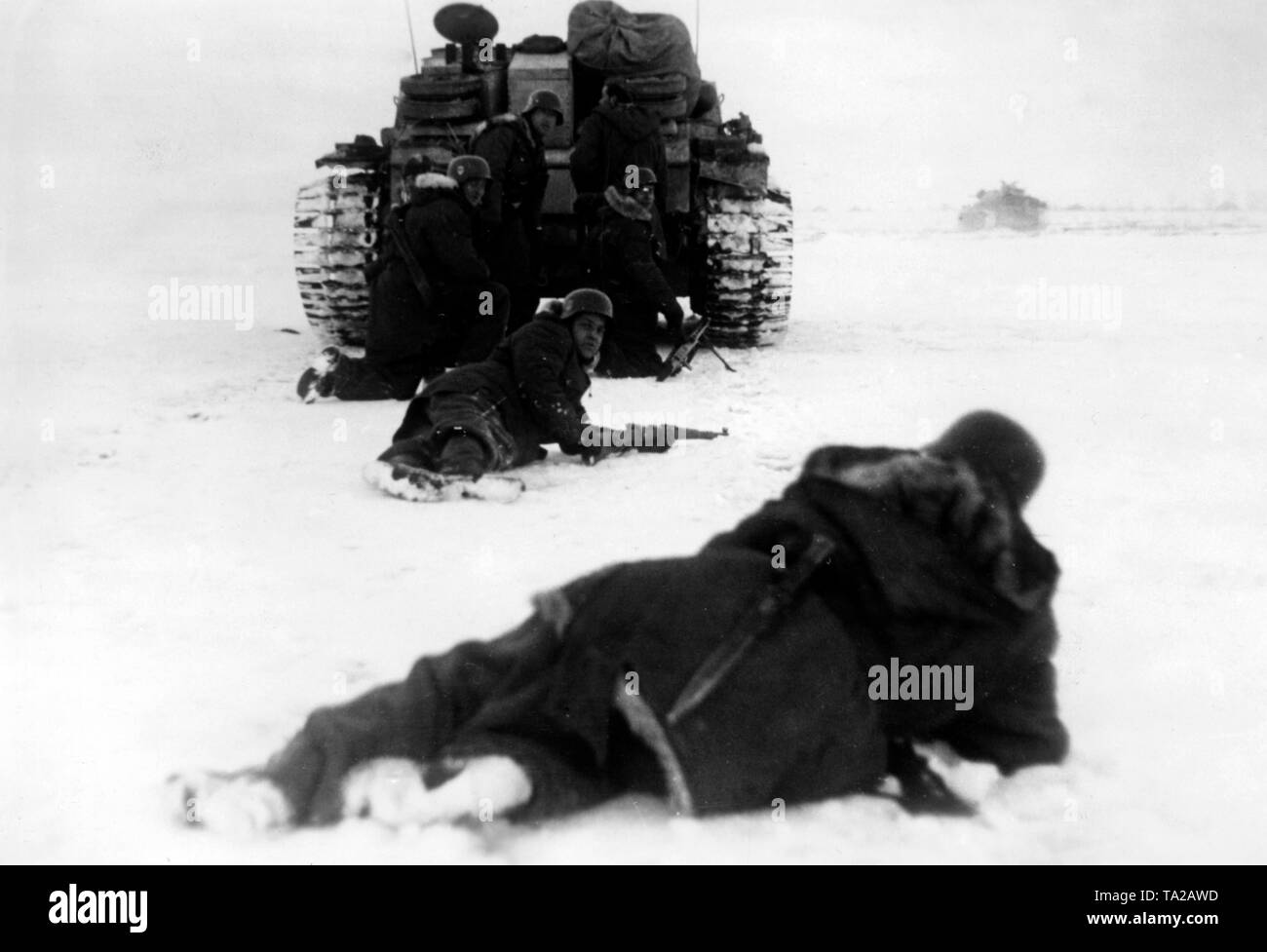 Under the cover of a battle tank (presumably Panzer IV), SS grenadiers ...