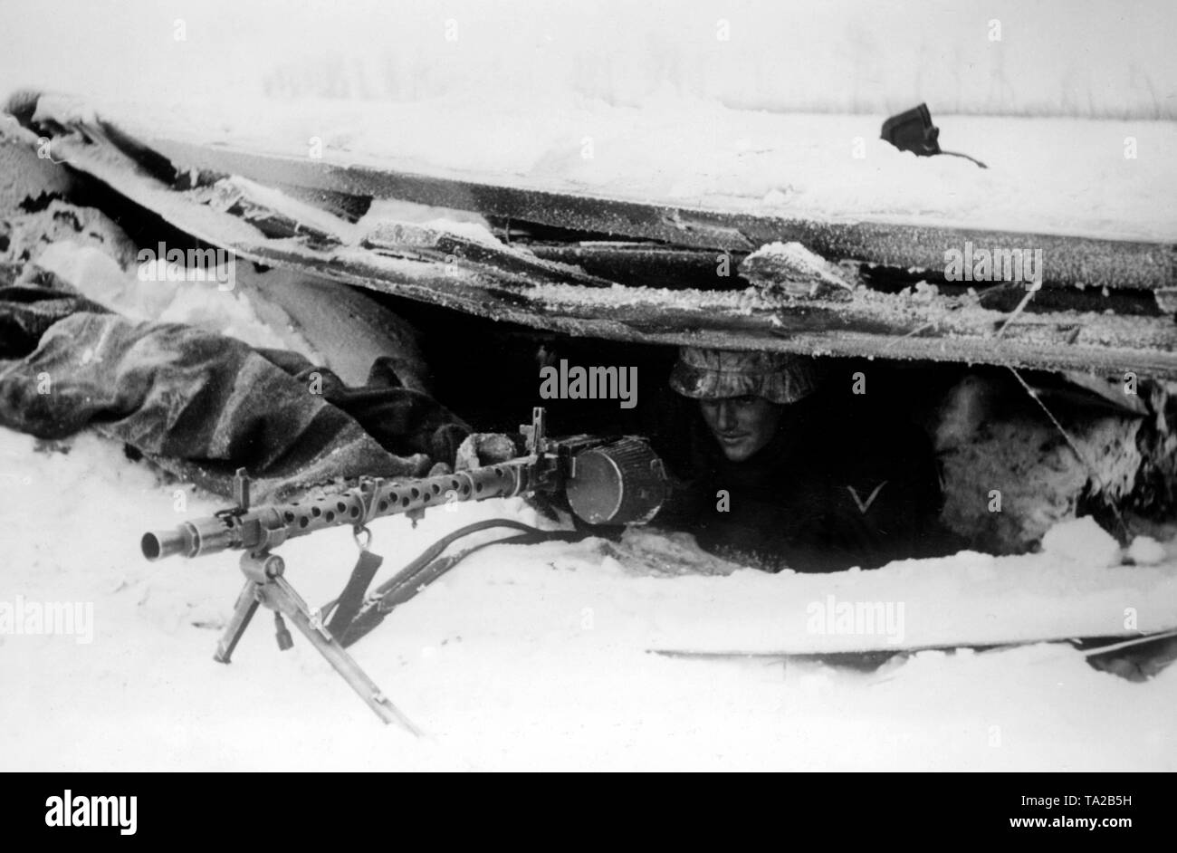 A German Wehrmacht soldier armed with an MG 34 machine gun waits for a ...