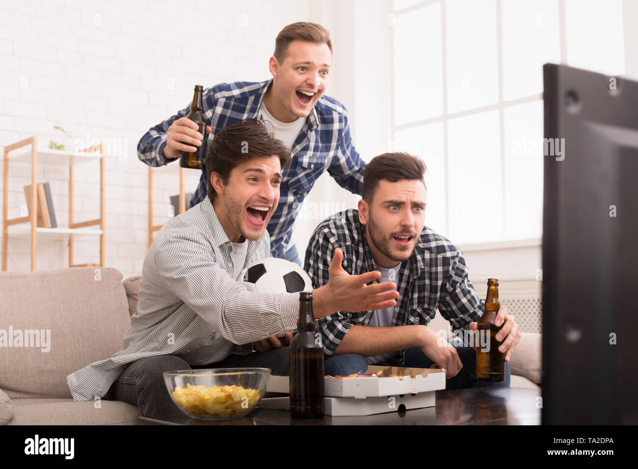 Soccer Fans Emotionally Watching Game In Living Room Stock Photo - Alamy