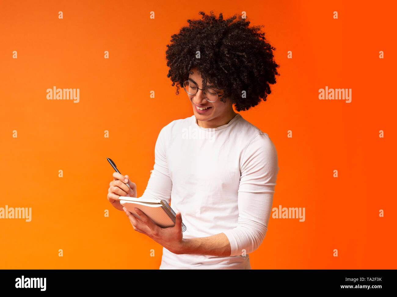 Cute african american millennial guy taking notes Stock Photo - Alamy