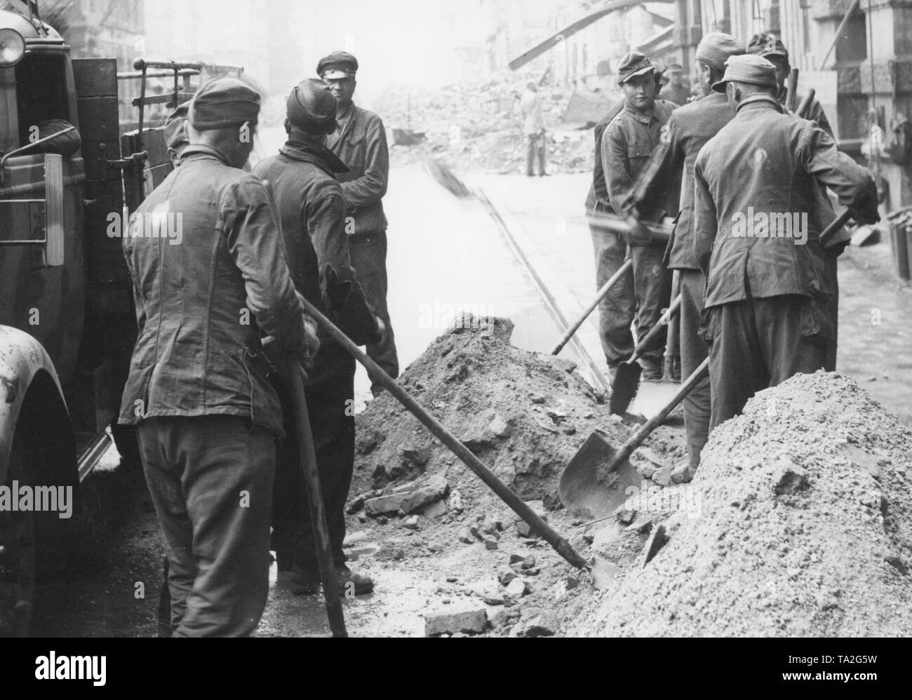 German war prisoners clear the rubble in the Schellingstrasse in Munich ...