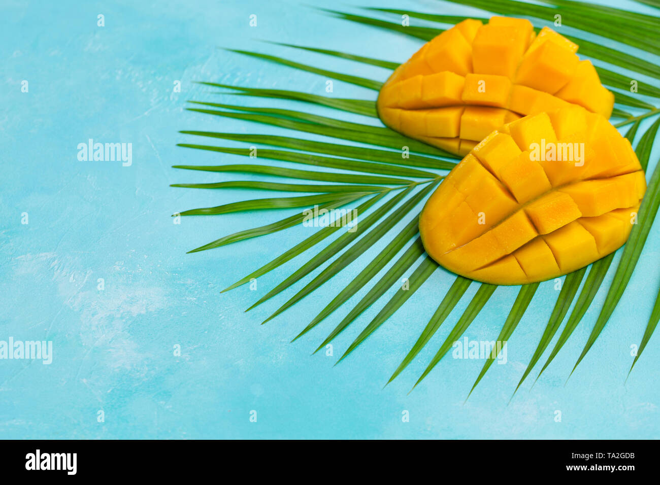 Fresh mango on a palm leaf. Blue background. Top view. Copy space Stock ...
