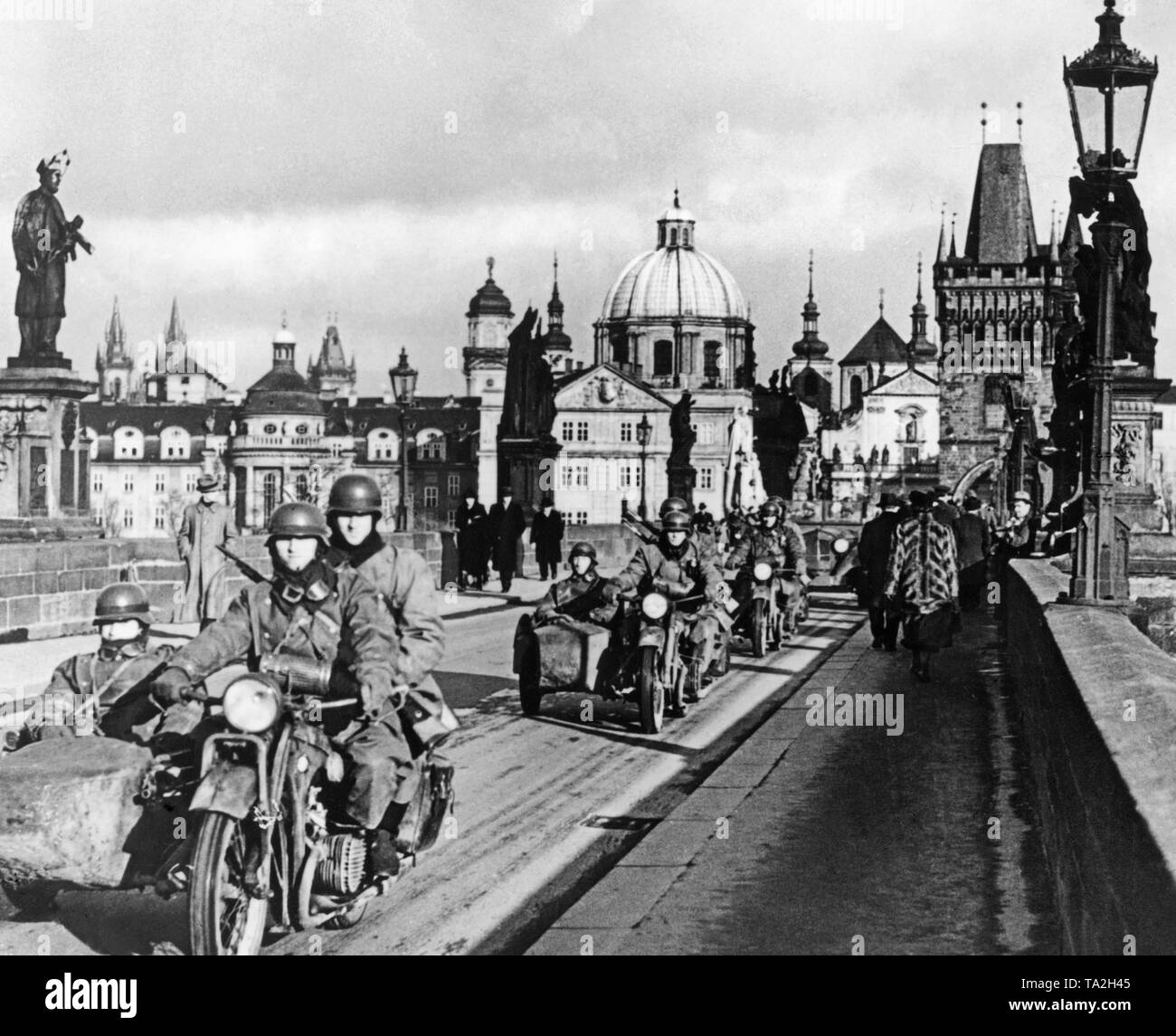 The Wehrmacht marches into Prague. The armed soldiers ride motorcycles ...