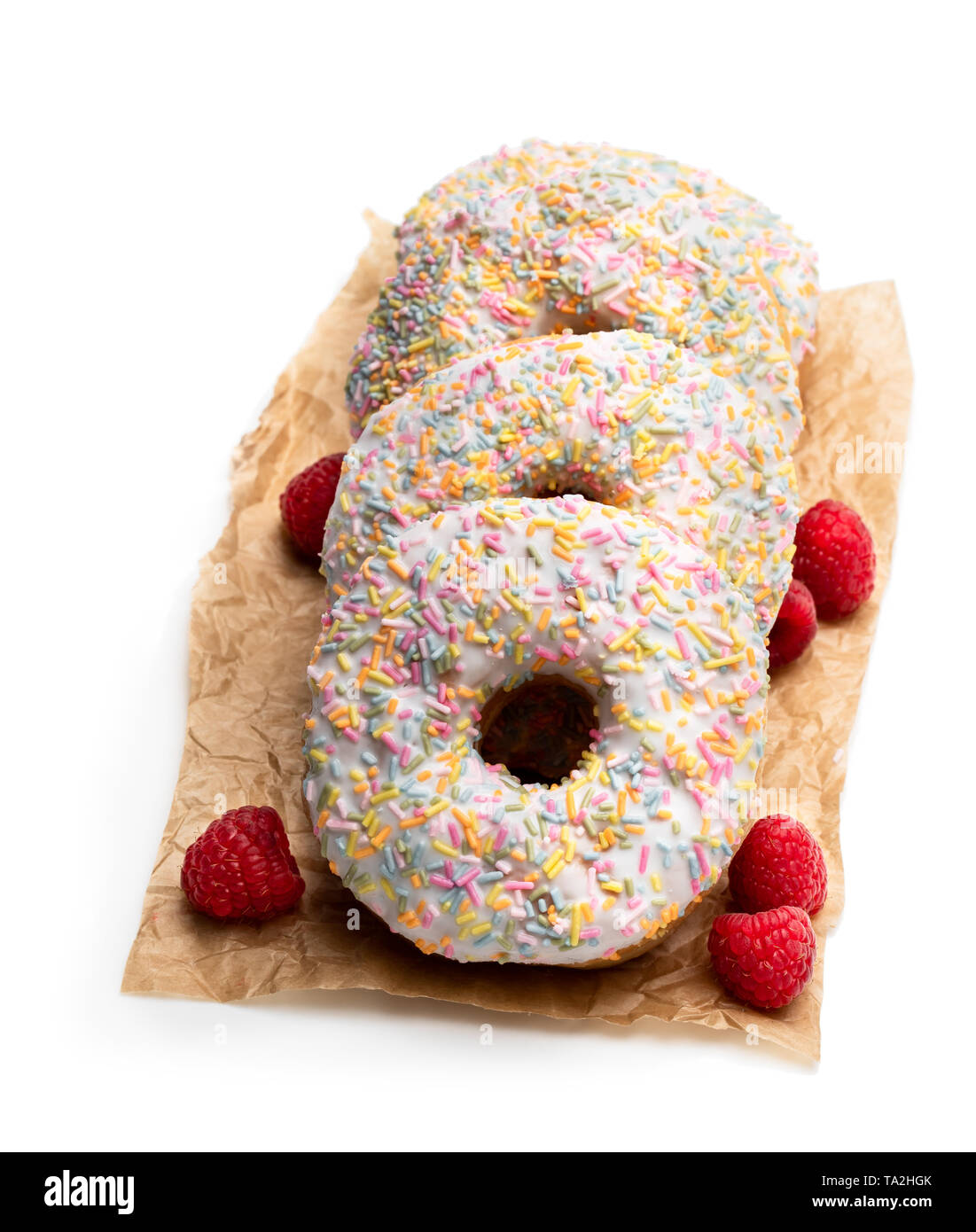 Pink doughnuts with sprinkles and fresh raspberry isolated on white ...
