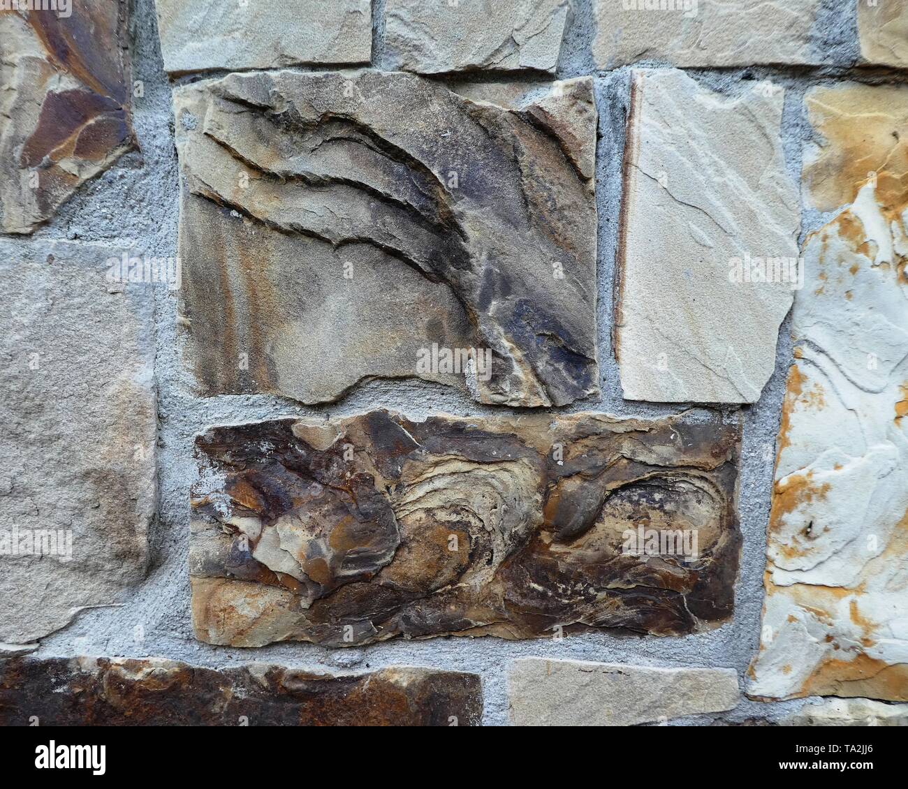 Closeup image of a natural paving stone embedded in a retaining wall ...