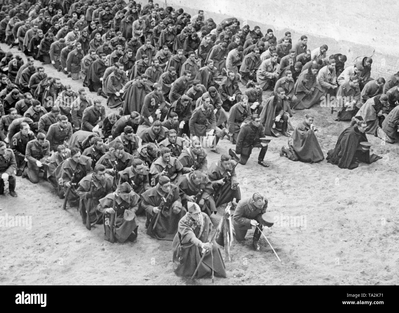 The photo shows kneeling officer candidates in uniform and loden cape ...
