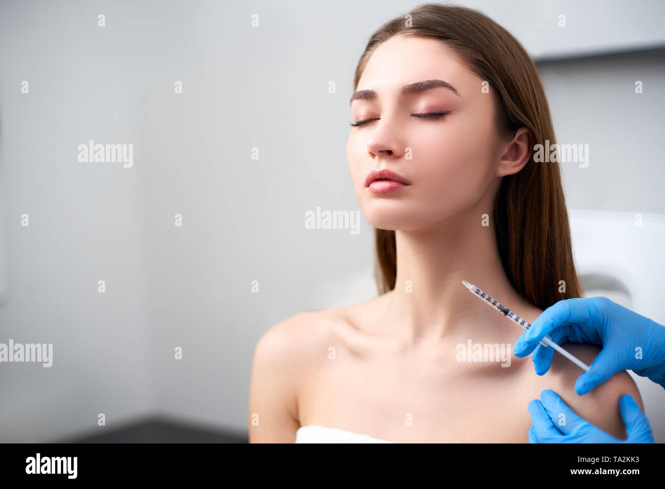 Beautician doctor with botulinum toxin syringe making injection to ...