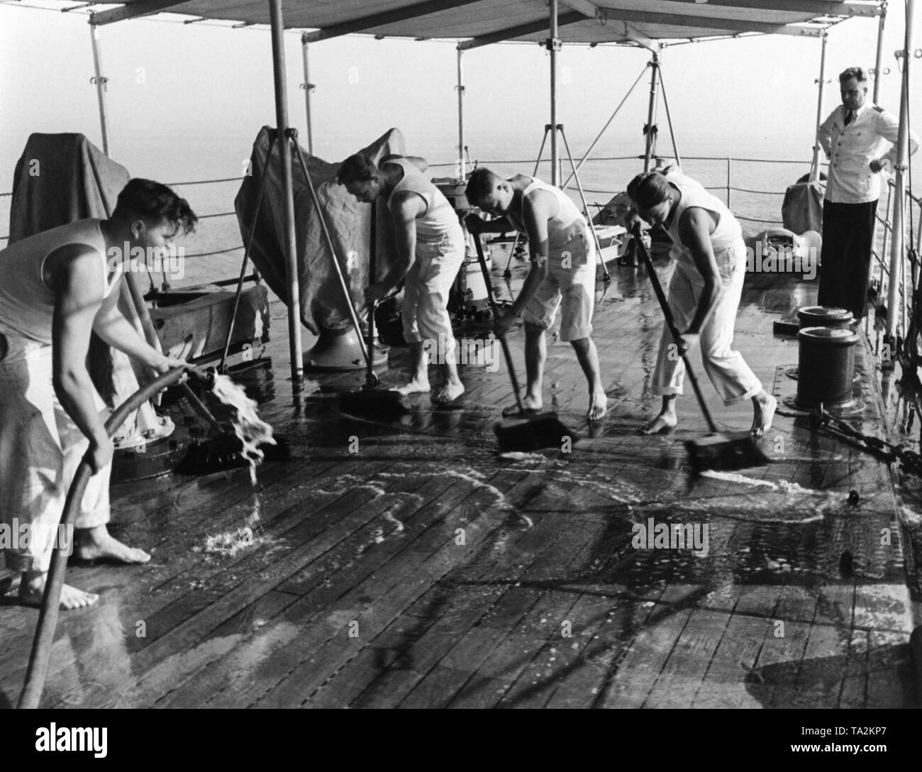 The picture shows how parts of the crew scrub the deck, in the ...