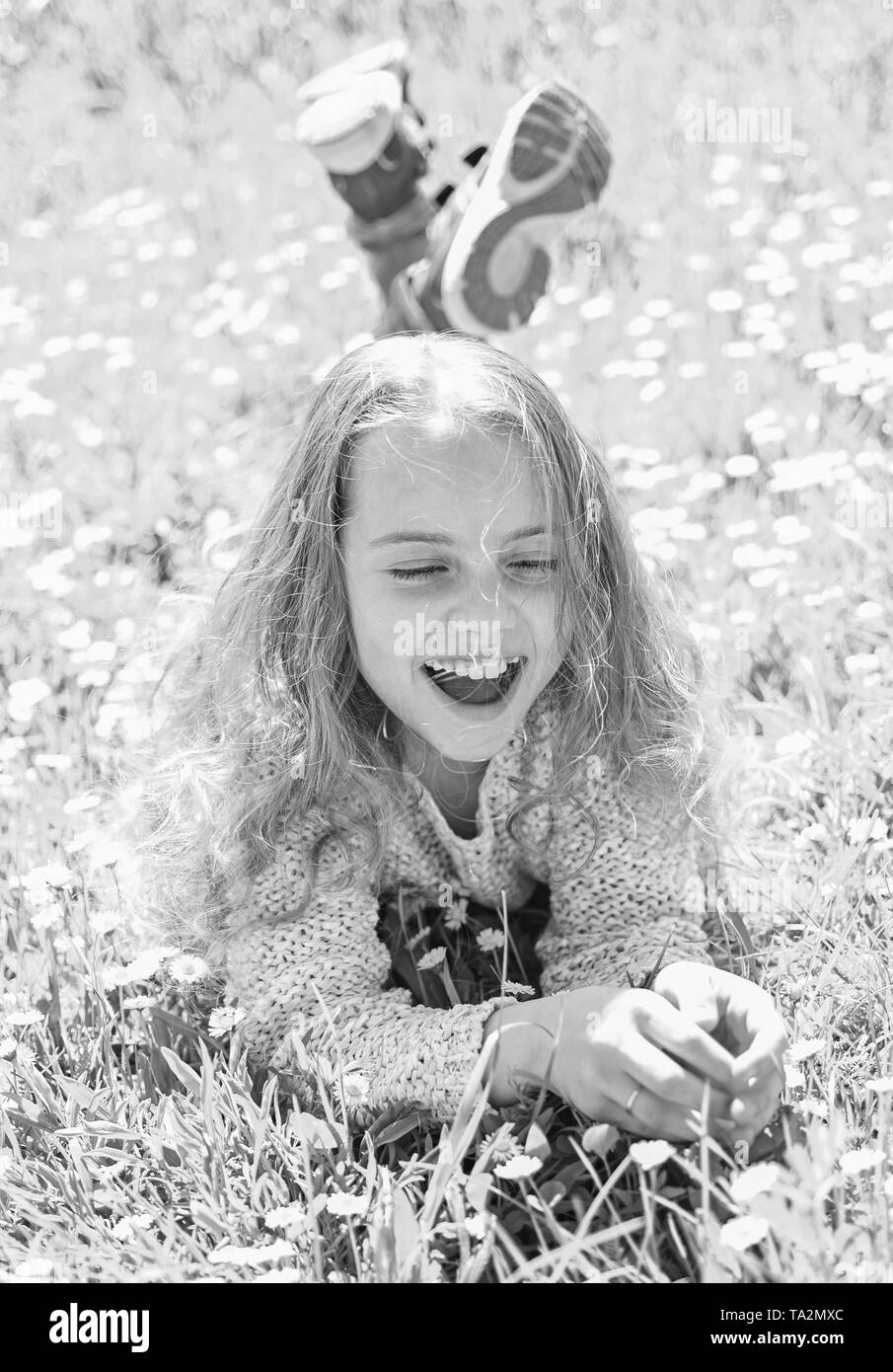Girl lying on grass, grassplot on background. Child enjoy spring sunny ...