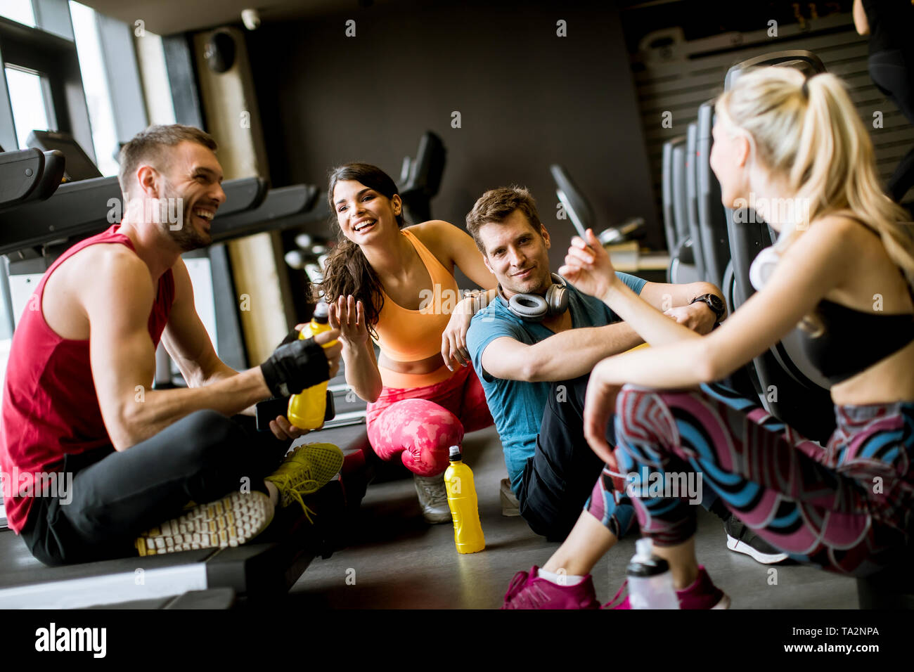 Group of young people in sportswear talking in a gym after a workout ...