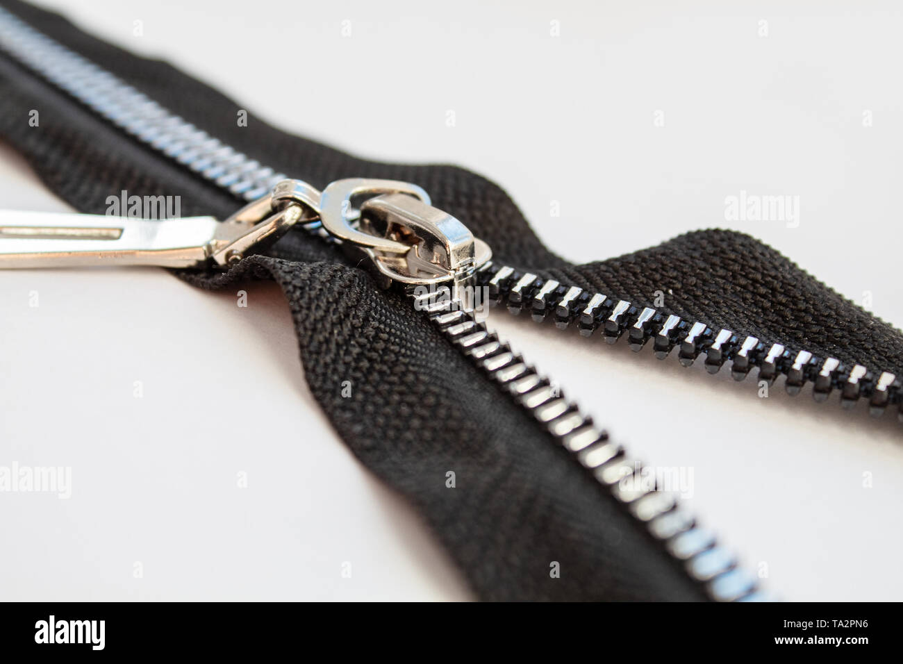 black metal open zipper closeup isolated on white background macro ...