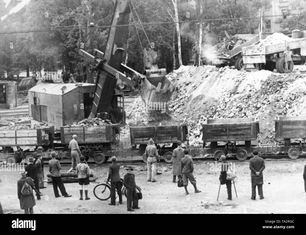 The wagons of a rubble transporting train are loaded with debris, while ...