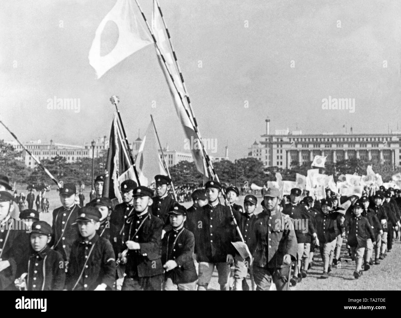 Students of a Tokyo middle school waving flags at the Tokyo Imperial ...