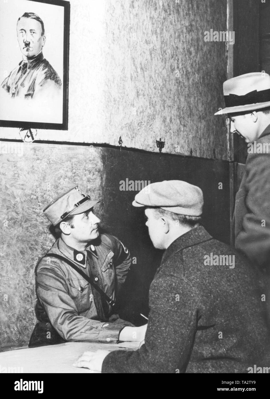 Two men enroll at a uniformed SA man in an office of the SA in a venue ...