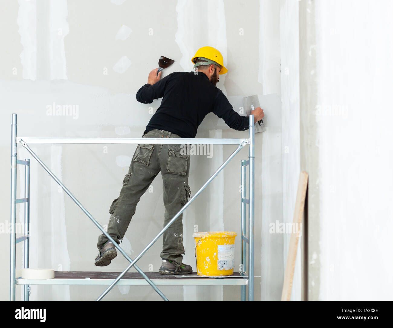 Interior construction, worker plastering gypsum board wall Stock Photo ...
