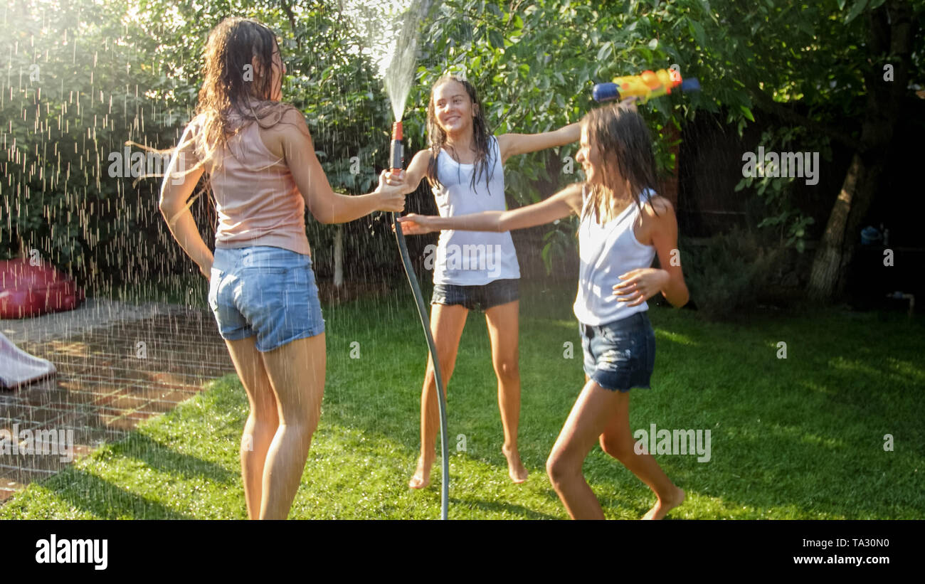 Photo of three cheerful teenage girls dancing in the backyard garden ...