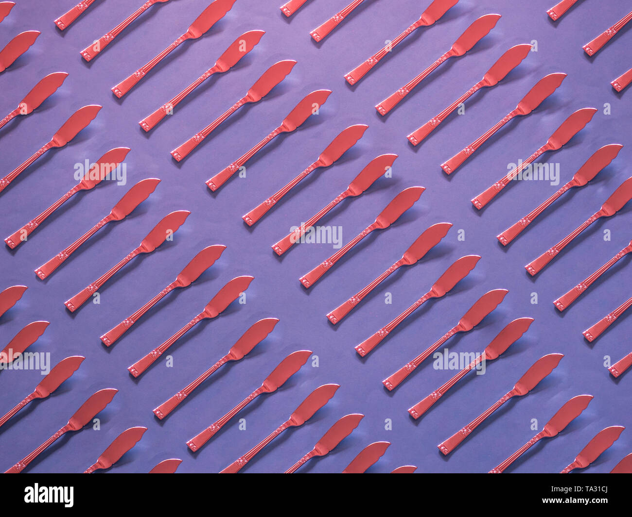 Red spread knives pattern on purple background Stock Photo - Alamy