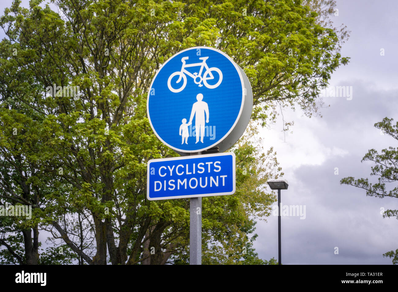 A sign, requesting that cyclists dismount Stock Photo - Alamy