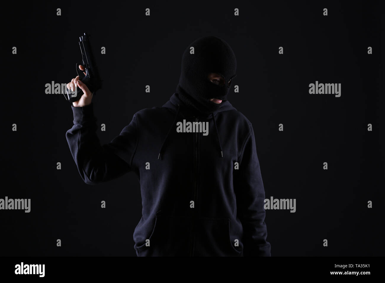 Bandit with gun on dark background Stock Photo - Alamy