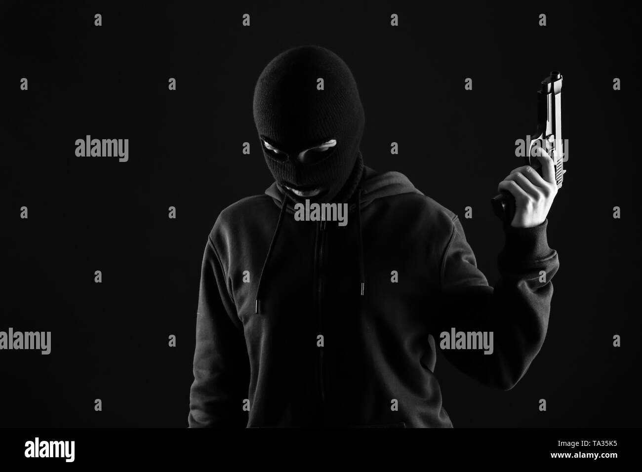 Bandit with gun on dark background Stock Photo - Alamy