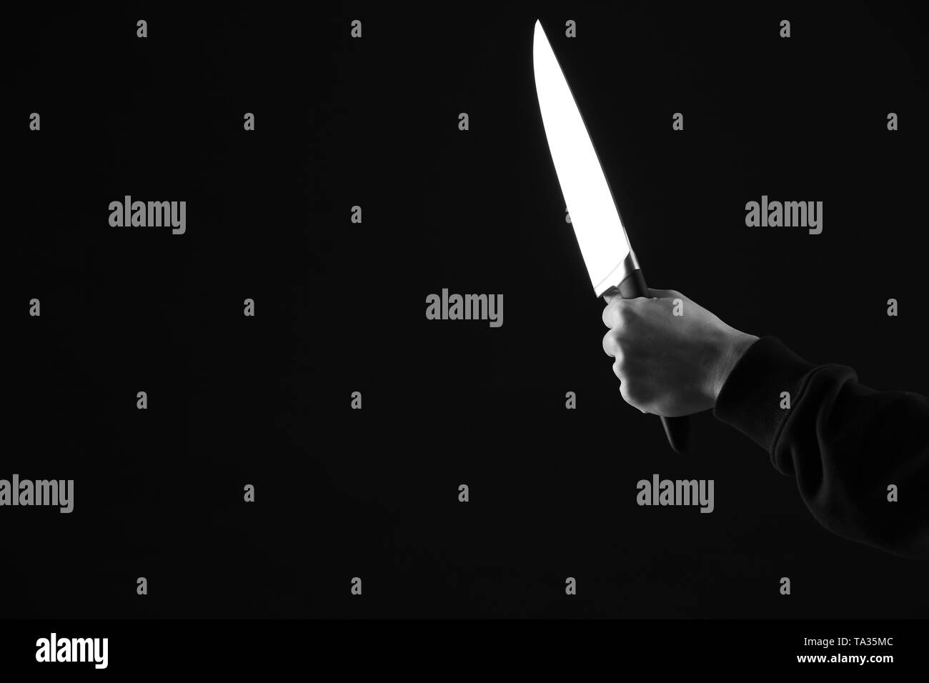 Bandit with knife on dark background Stock Photo - Alamy