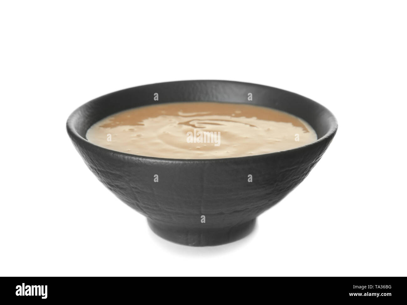 Bowl of tasty tahini on white background Stock Photo - Alamy