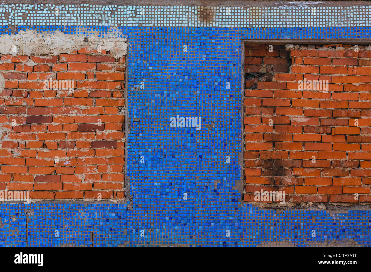 Brick filled windows on blue glass tiles wall Stock Photo - Alamy
