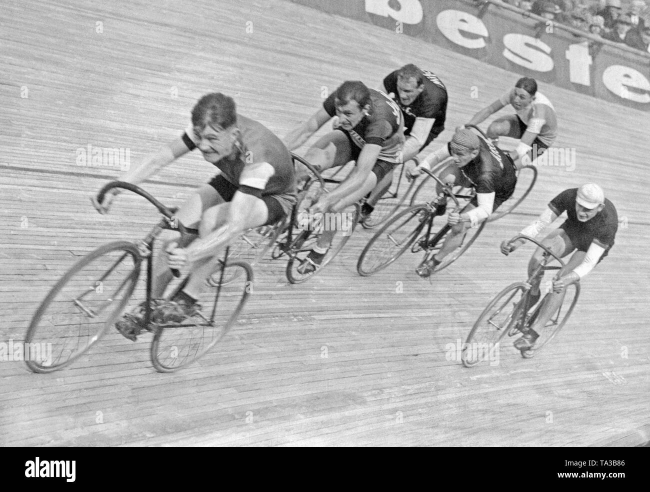 The riders of a track cycling race in a steeply banked track in the ...