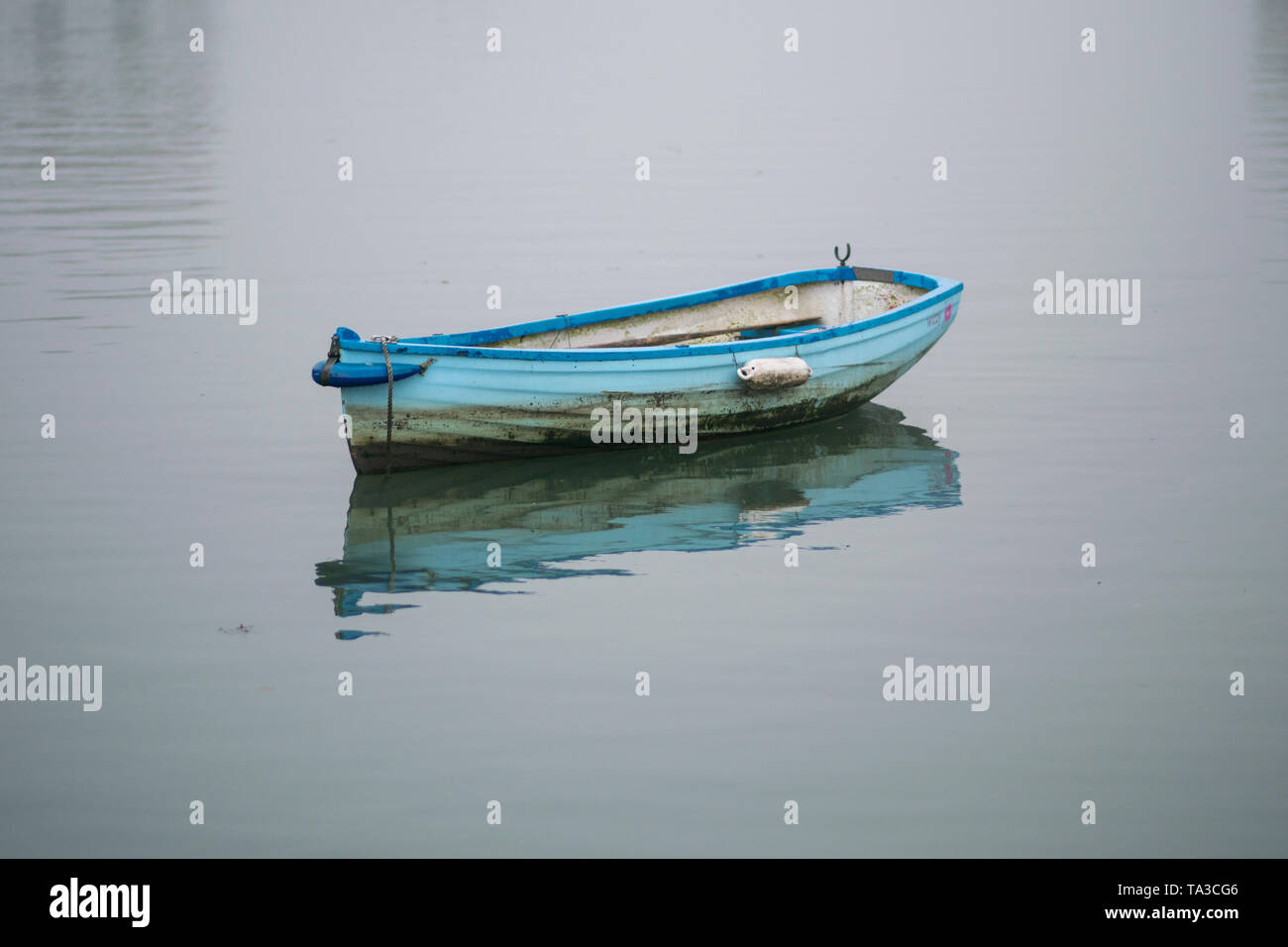 Small blue rowing boat with reflection Stock Photo - Alamy