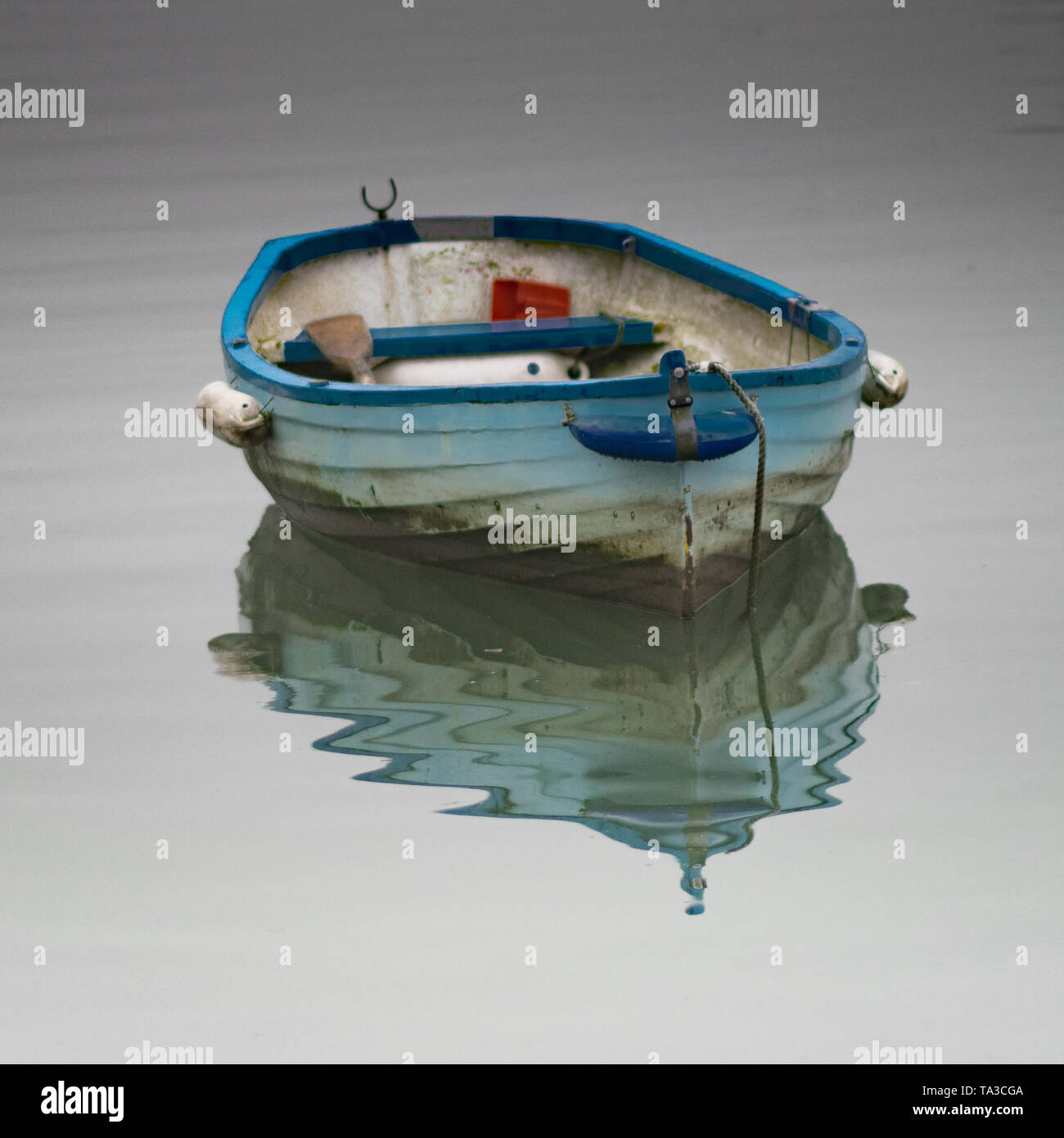 Small blue rowing boat with reflection Stock Photo - Alamy