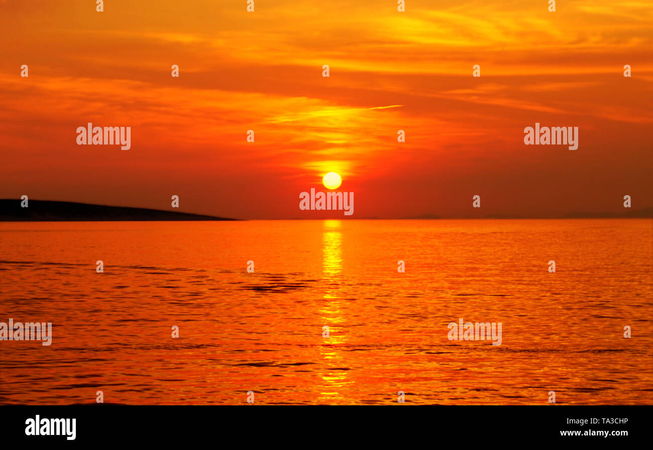 Vivid orange color tone sea sunset on a beautiful sea surface and ...