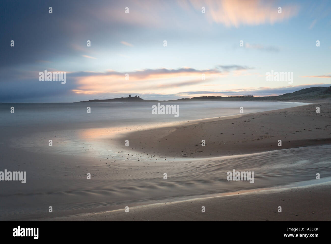 Beach with distant dunstanburgh castle hi-res stock photography and ...