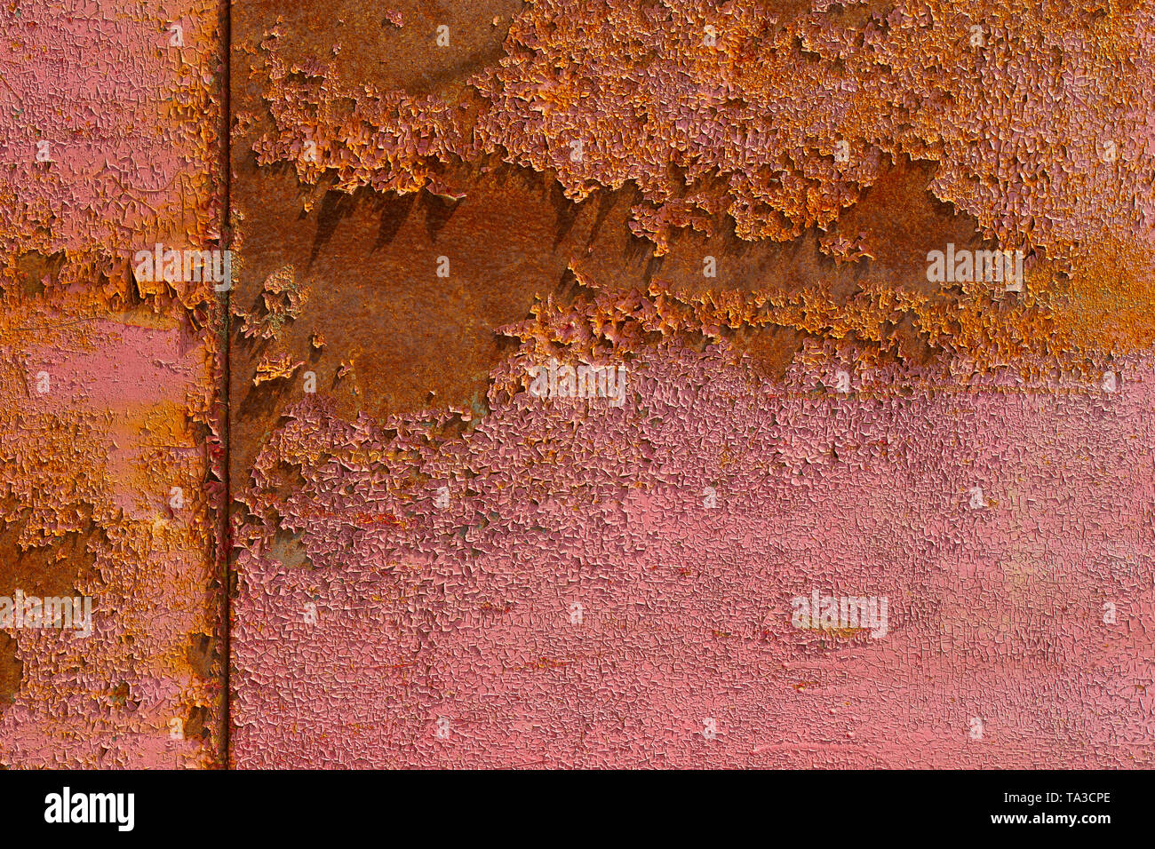 Red peeling paint on rusted sheet metal texture with vertical seam ...