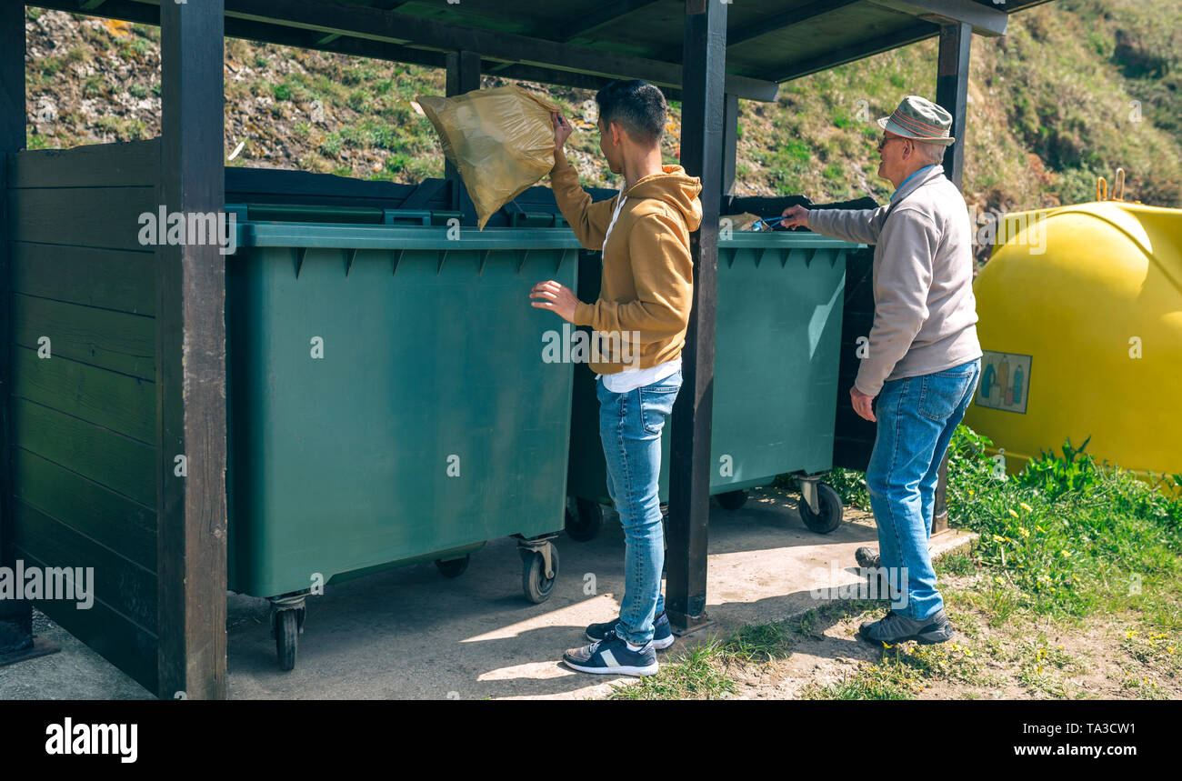 Men throwing garbage to container Stock Photo - Alamy