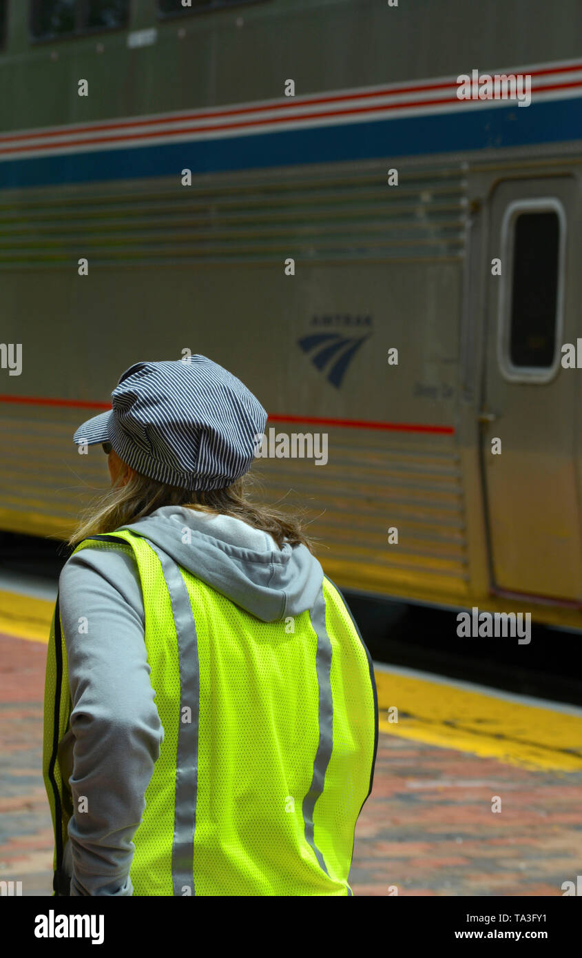 A station employee welcomes an arriving Amtrak passenger train at the ...