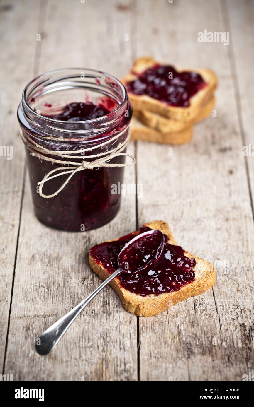 Toasted cereal bread slices and jar with homemade wild berries jam and ...
