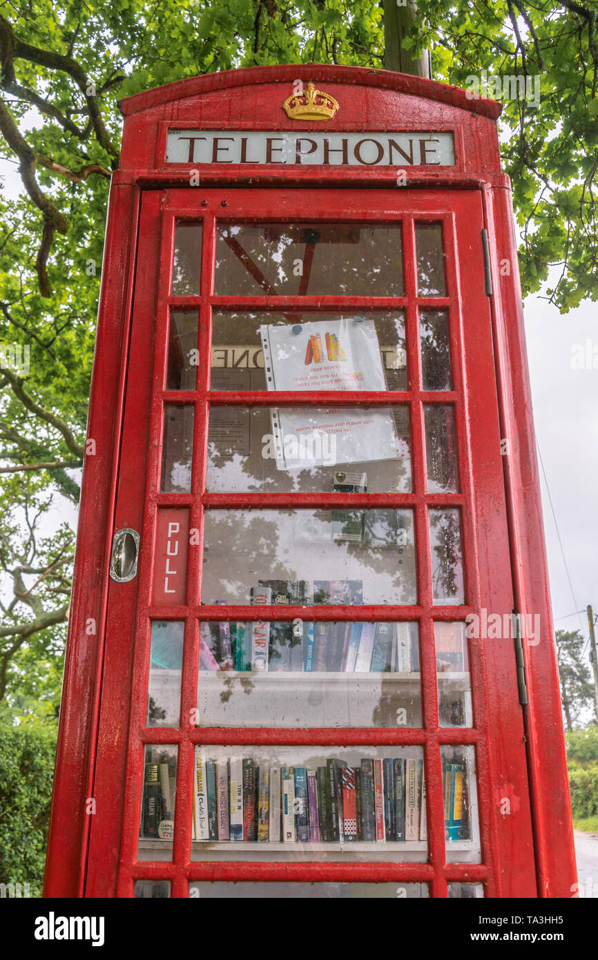 Red old telephone booth which has been converted to a library on a ...