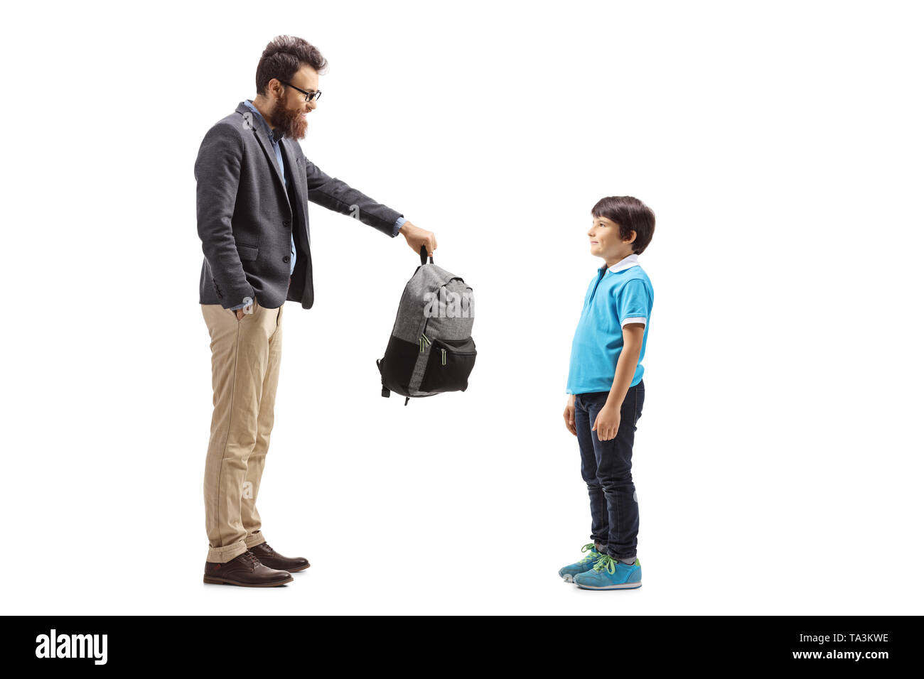 Full length shot of a father giving a backpack to his son isolated on ...